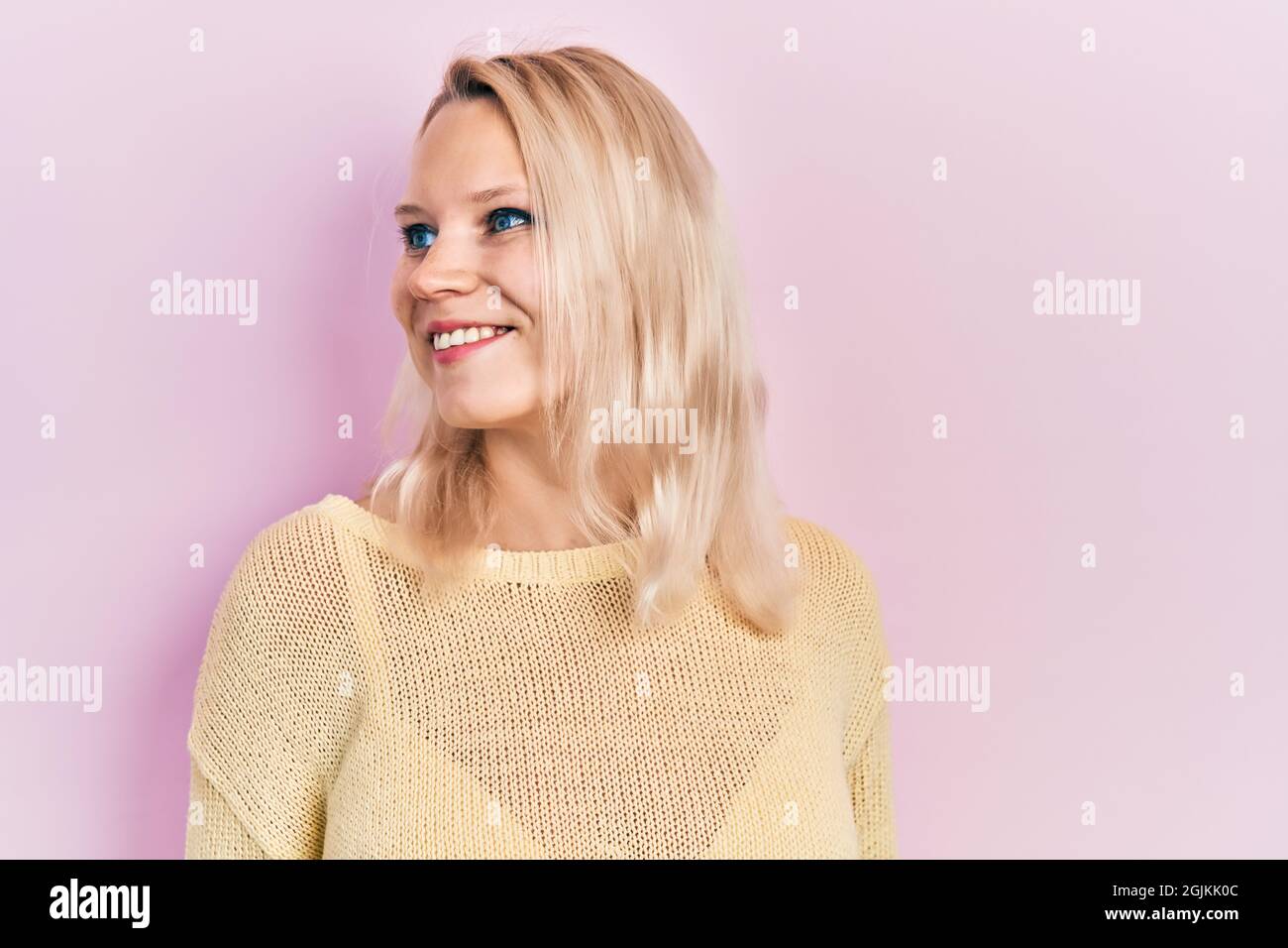 Beautiful caucasian blonde woman wearing casual winter sweater looking ...