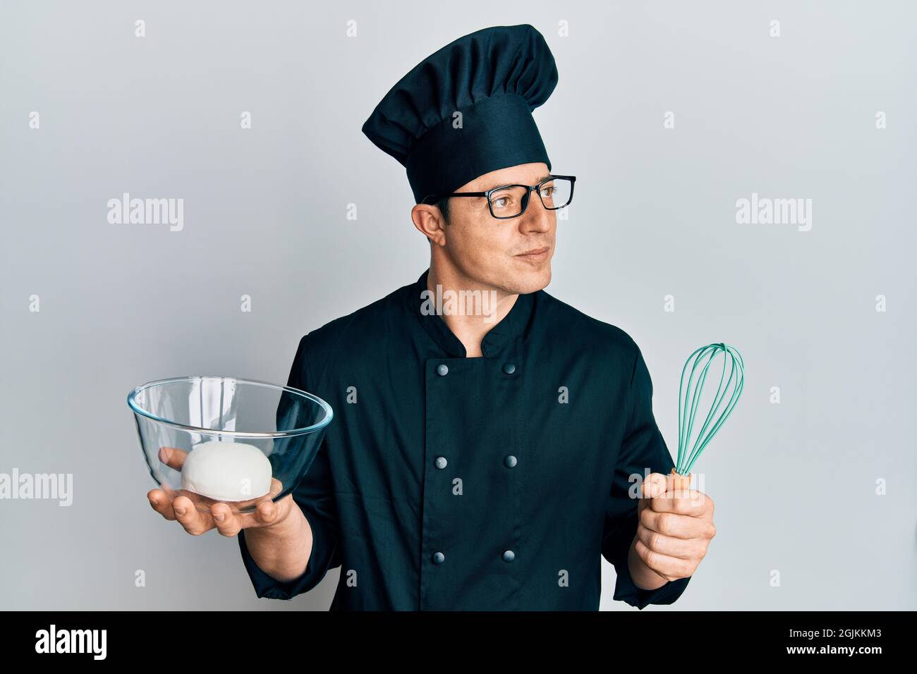 Handsome young man holding bread dough and blender smiling looking to ...