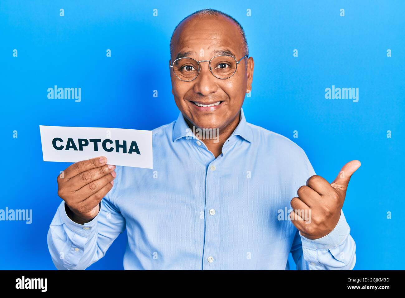 Middle age latin man holding captcha message paper smiling happy ...