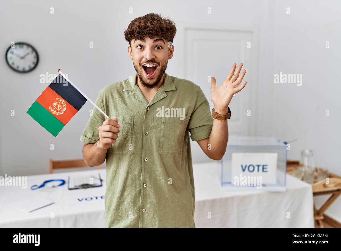 Young arab man at political campaign election holding afghanistan flag ...