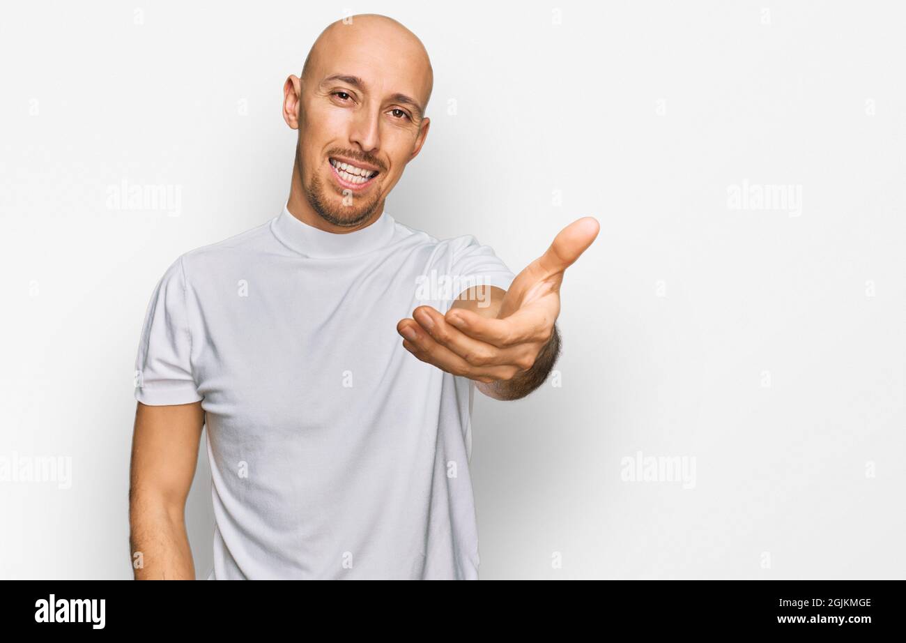 Bald man with beard wearing casual white t shirt smiling friendly ...