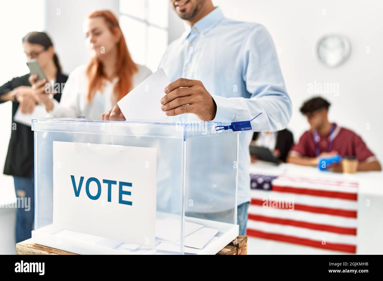 Young american voter man smiling happy putting ballot in voting box at ...