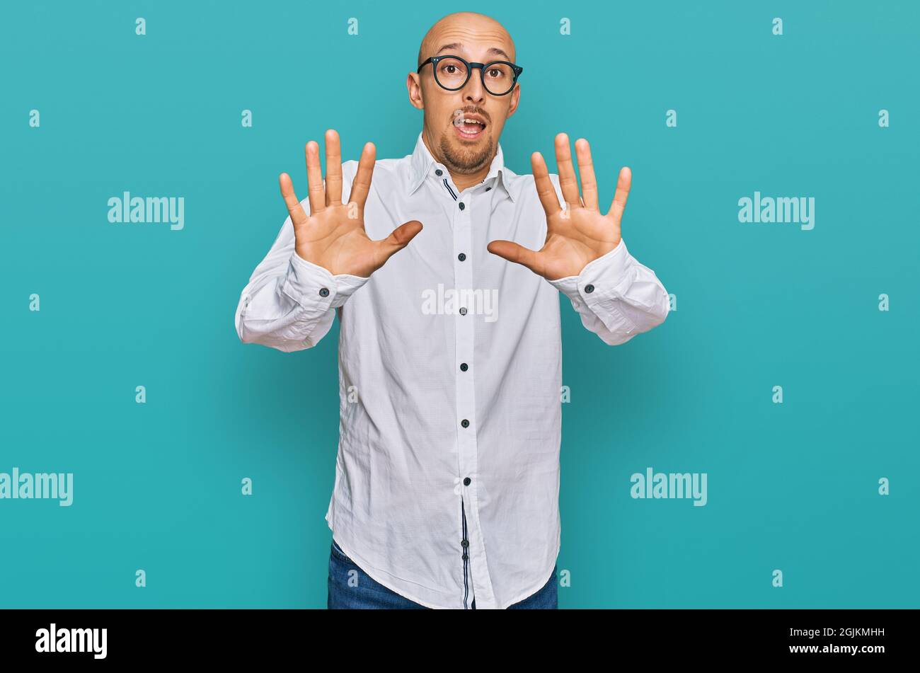 Bald man with beard wearing business shirt and glasses afraid and ...