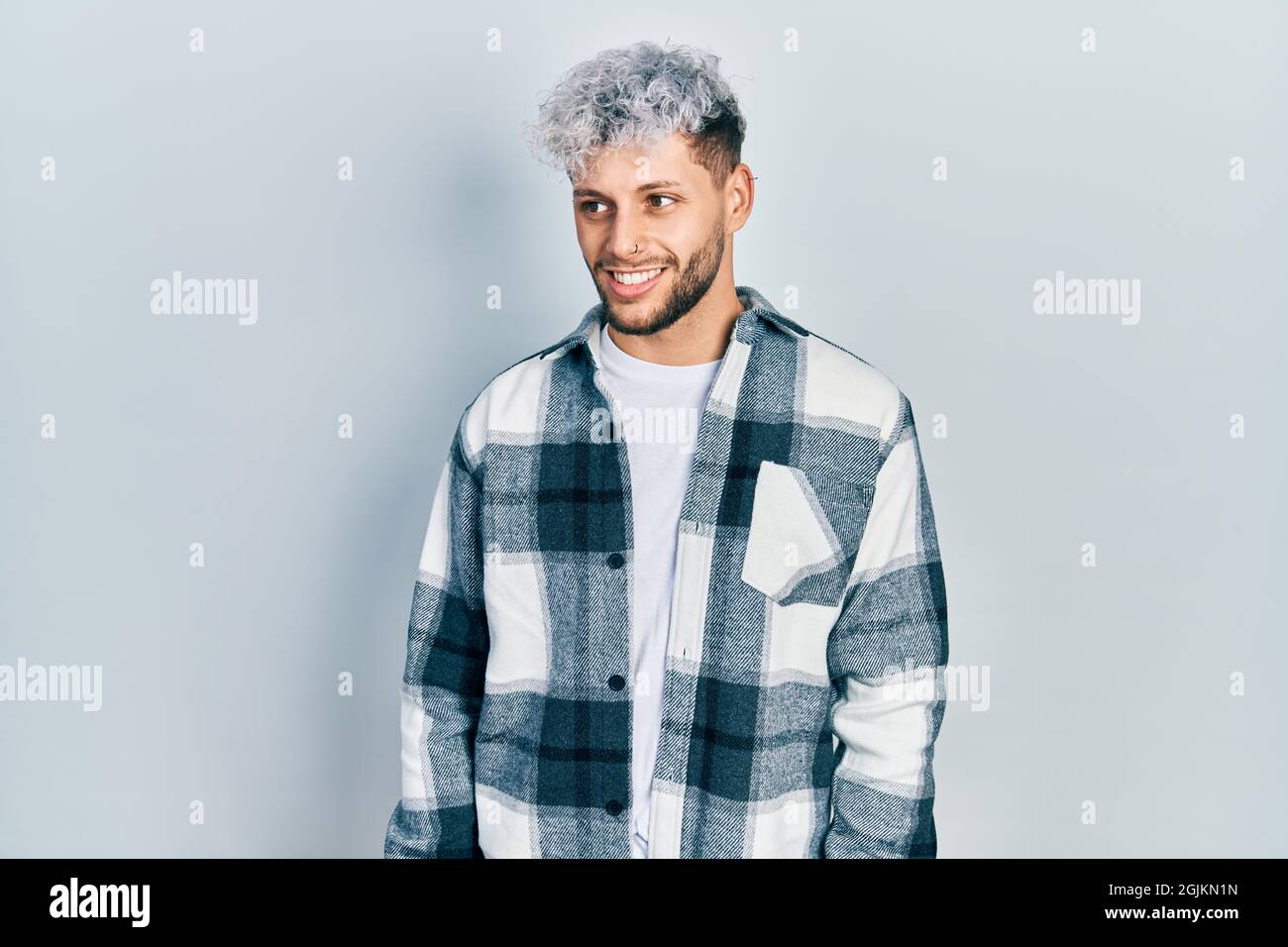 Young hispanic man with modern dyed hair wearing casual shirt looking ...