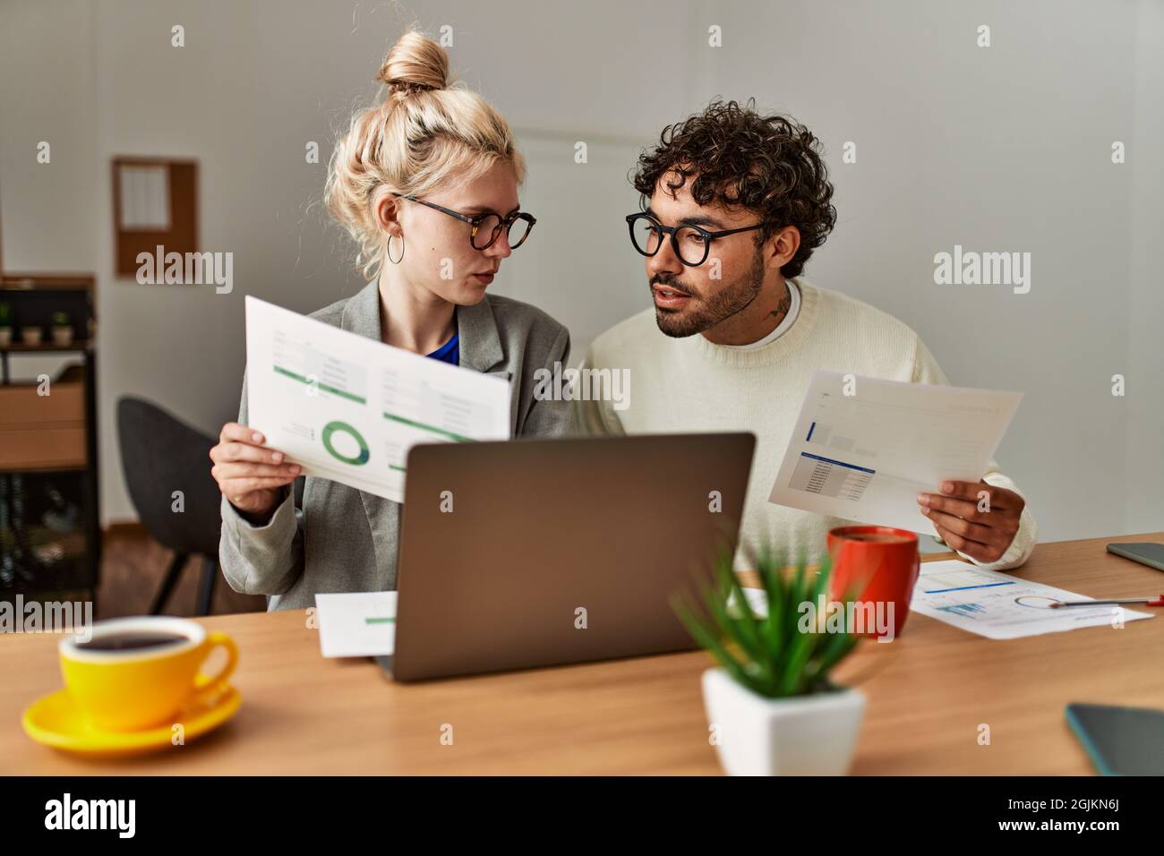 Two hispanic business workers concentrated working at the office Stock ...