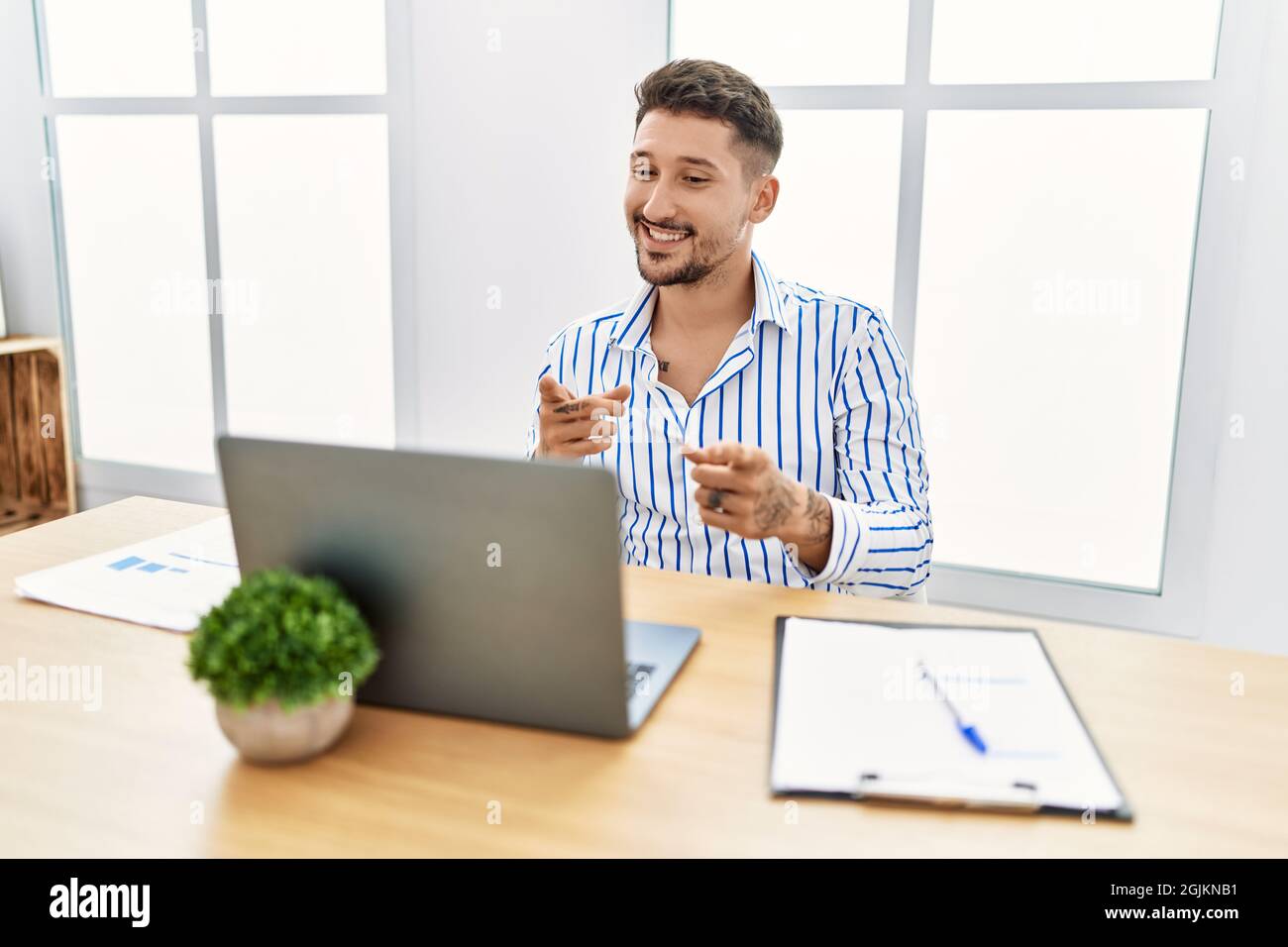 Young handsome man with beard working at the office using computer ...