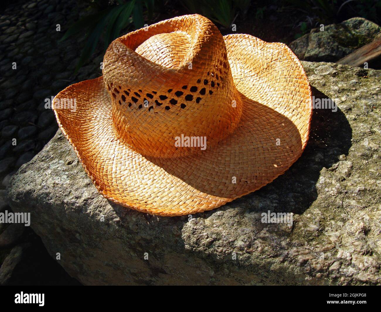 Straw hat on stone bench Stock Photo - Alamy
