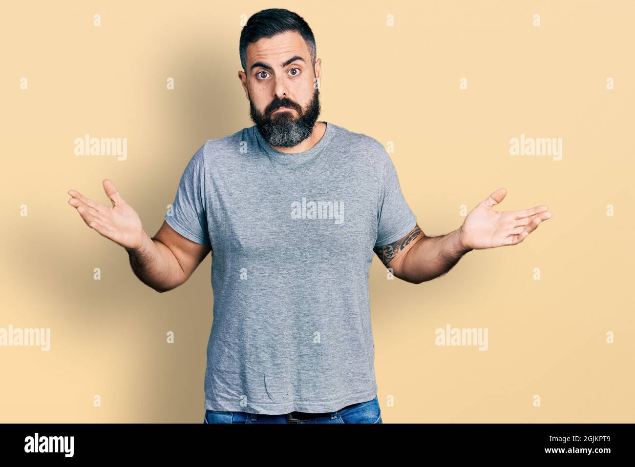 Hispanic man with beard wearing casual grey t shirt clueless and ...