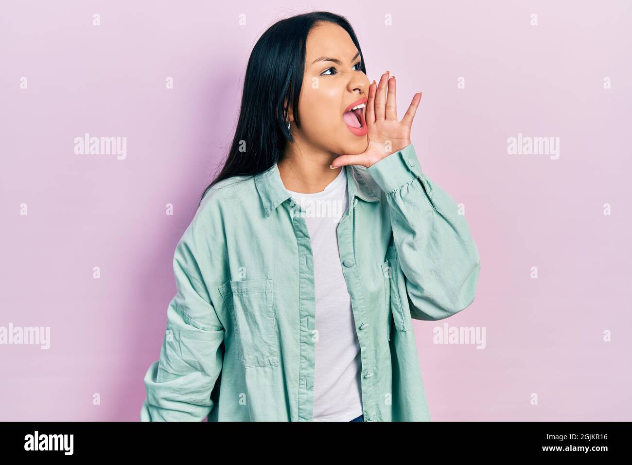 Beautiful hispanic woman with nose piercing wearing casual green jacket ...