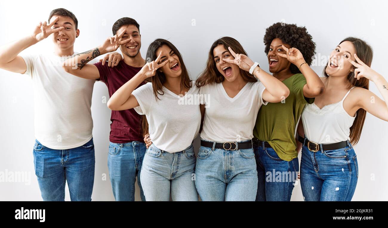 Group of young friends standing together over isolated background doing ...