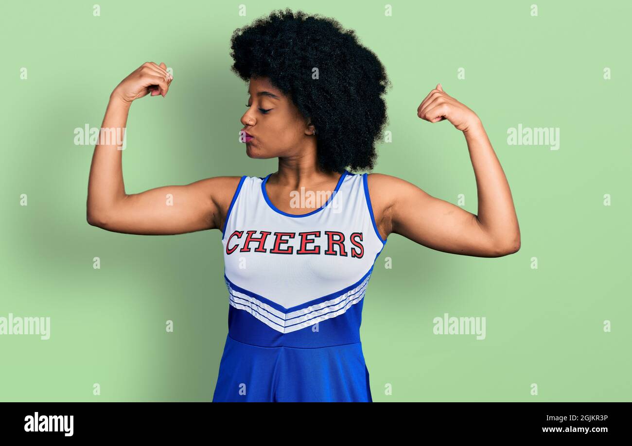 Young african american woman wearing cheerleader uniform showing arms ...