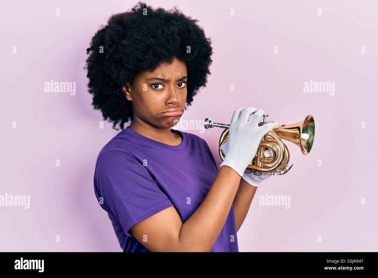 Young african american woman playing trumpet depressed and worry for ...