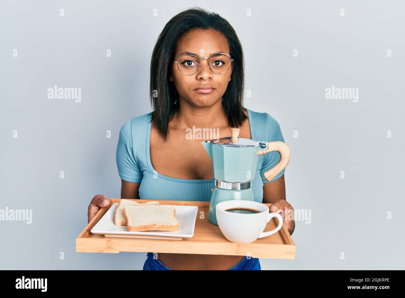 Young african american girl holding tray with breakfast food depressed ...