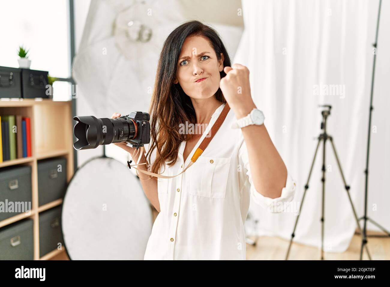 Beautiful caucasian woman working as photographer at photography studio ...