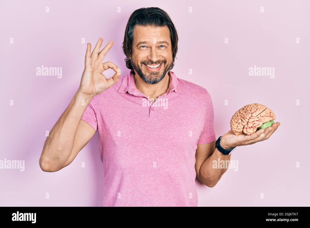 Middle age caucasian man holding brain doing ok sign with fingers ...