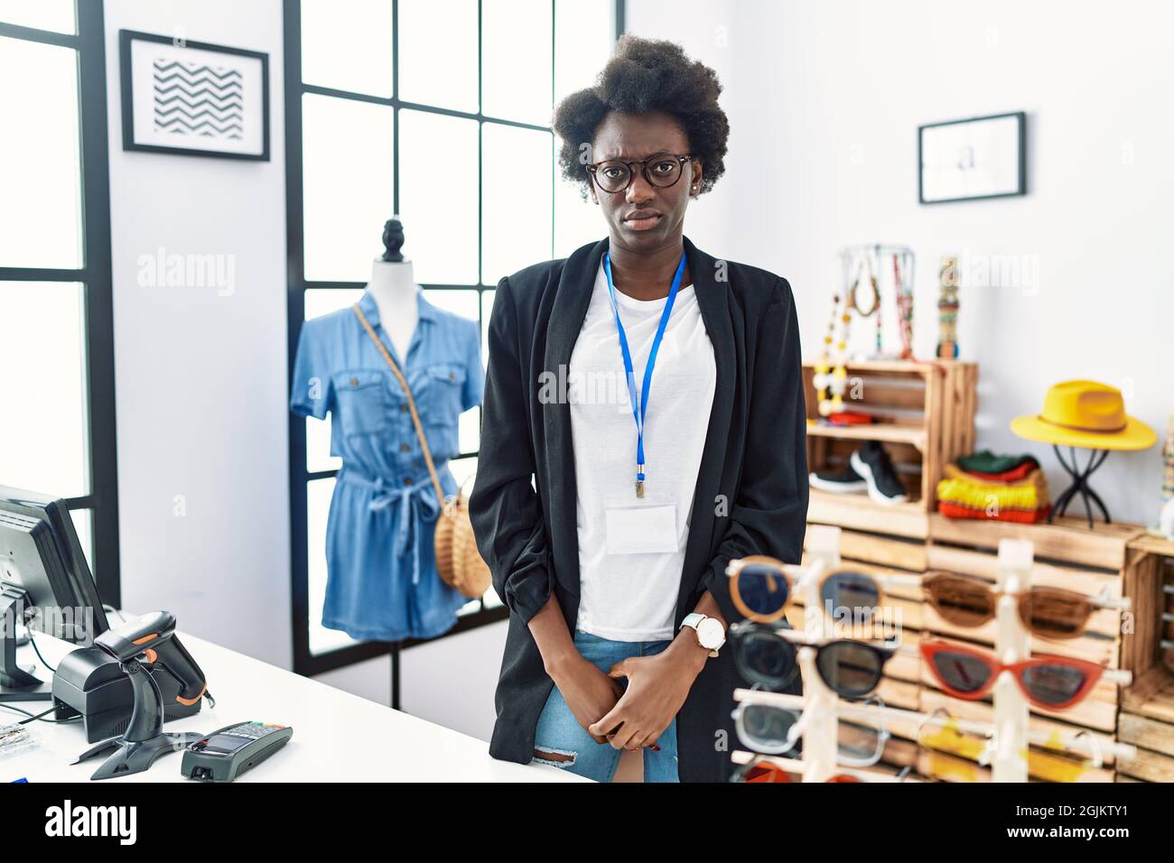 African young woman working as manager at retail boutique depressed and ...