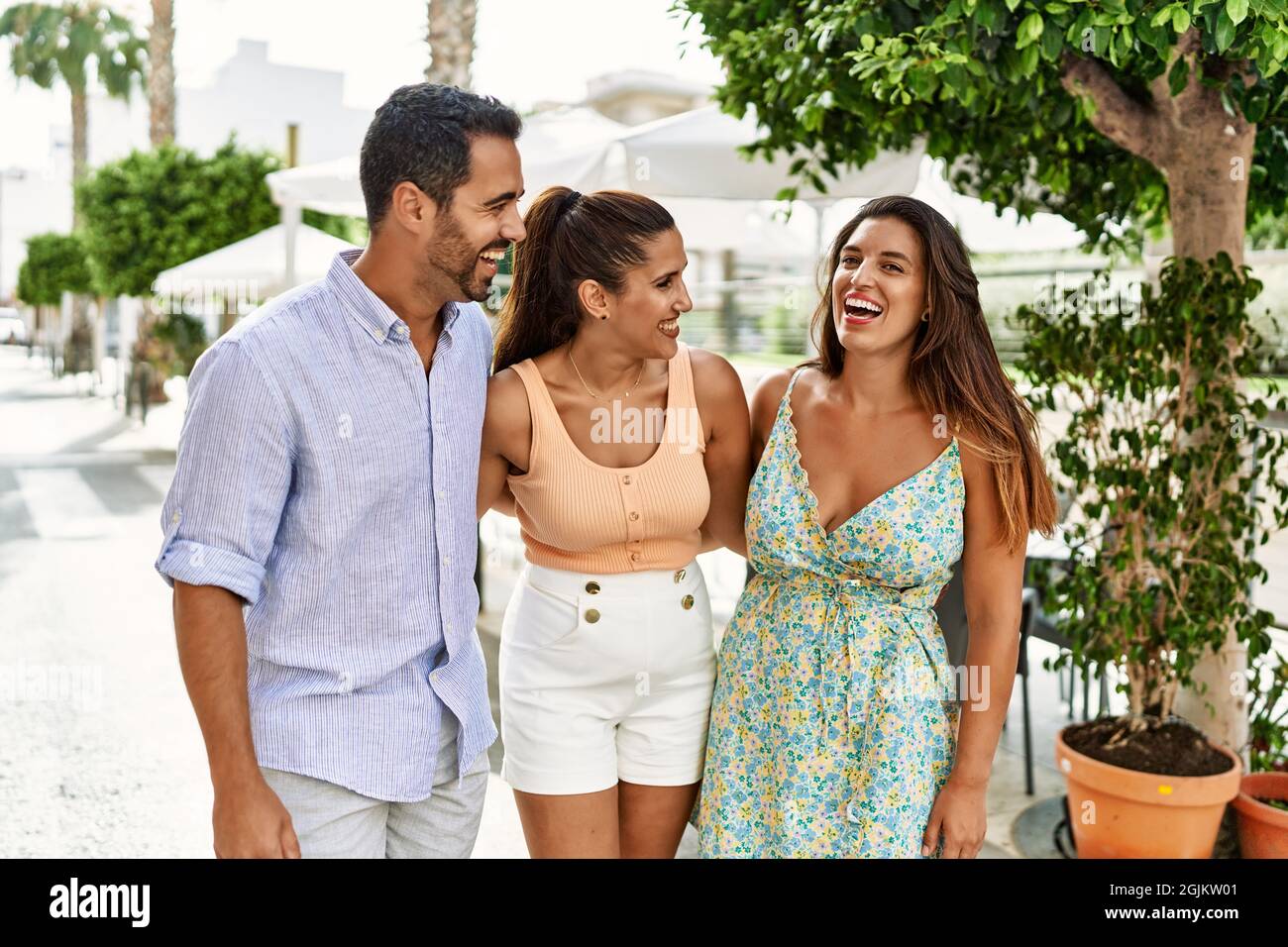 Three hispanic friends smiling happy and hugging at the city Stock ...