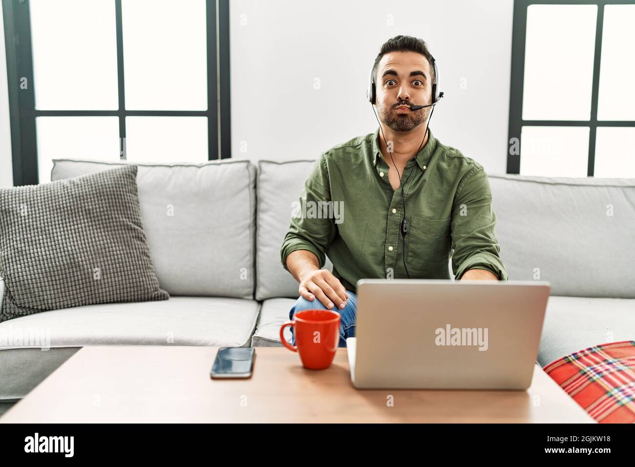 Young hispanic man with beard wearing call center agent headset working ...