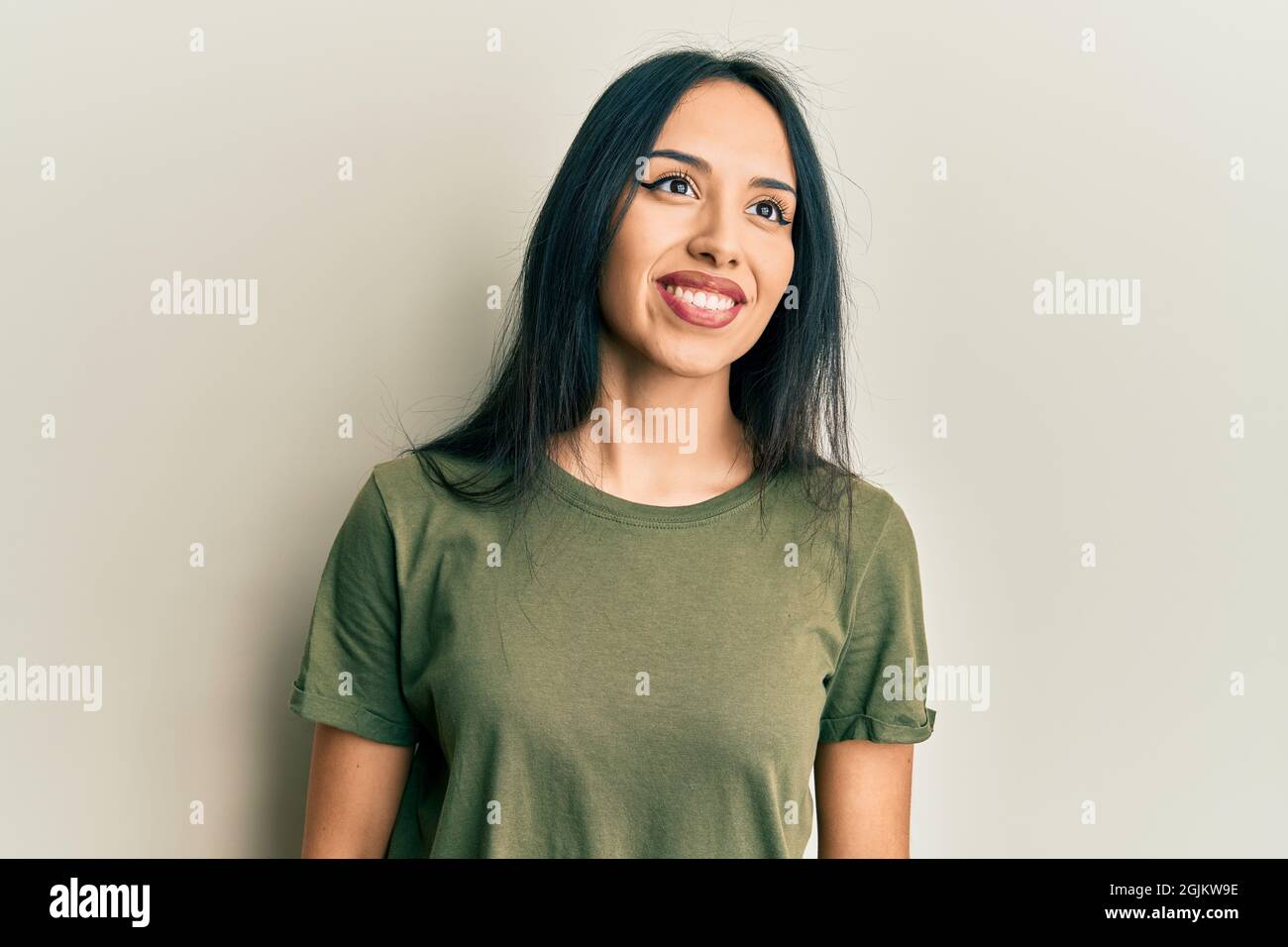 Young hispanic girl wearing casual t shirt looking away to side with ...