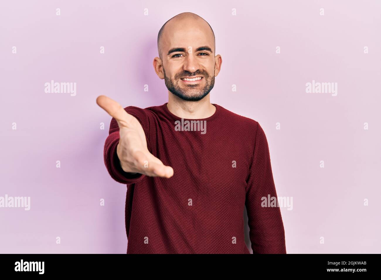 Young bald man wearing casual clothes smiling friendly offering ...