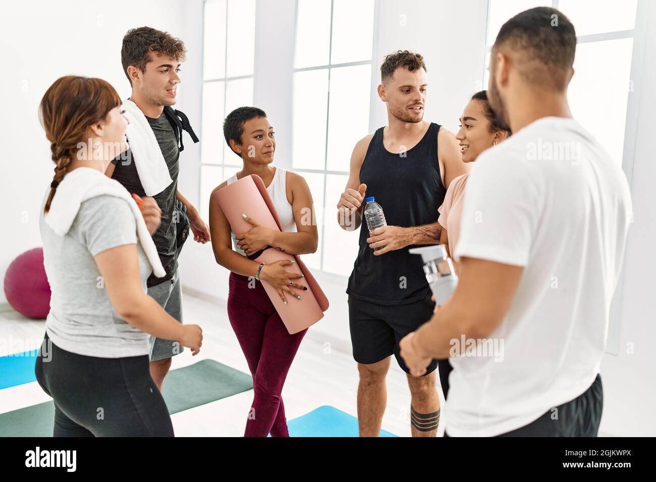 Group of young sporty people standing and speaking at sport center ...