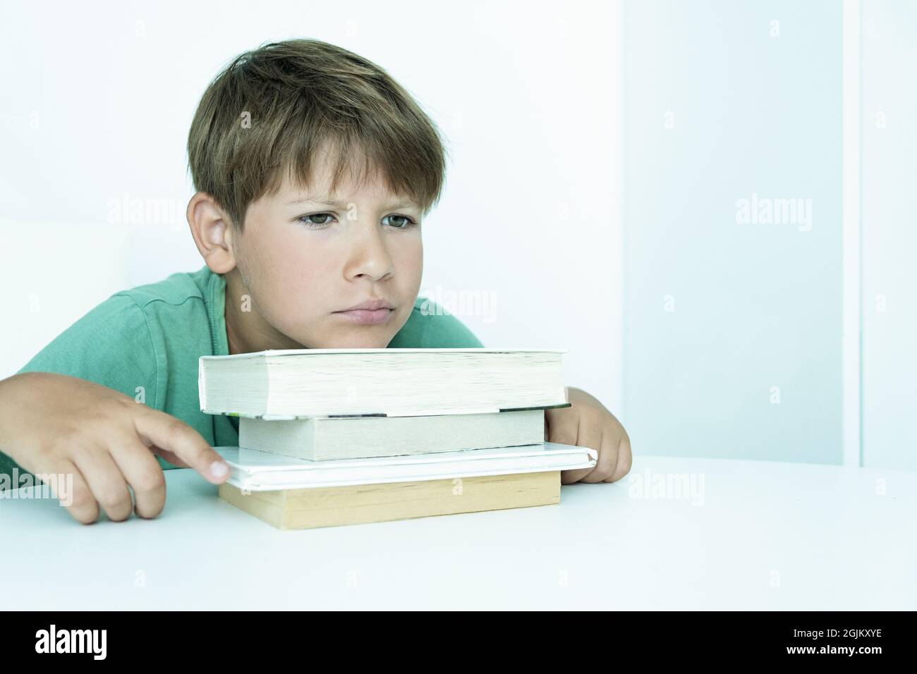 Sad boy with book does school homework. Back to school. Unhappy ...