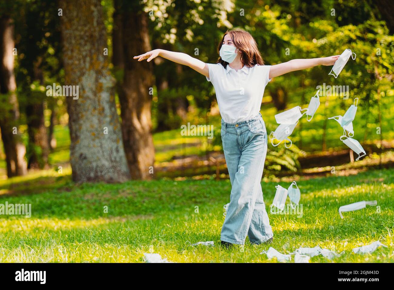 Full-length photo of a young woman wearing a facial medical mask ...