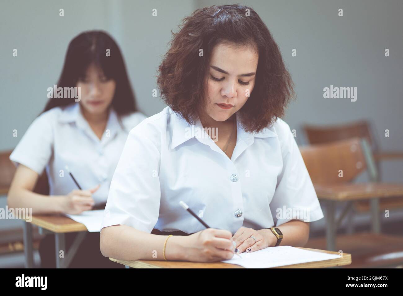 Asian female college students taking notes while studying in a ...