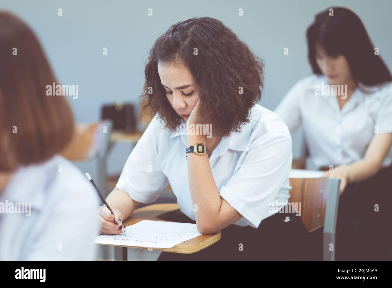 Group of Asian female college students taking notes while studying in a ...