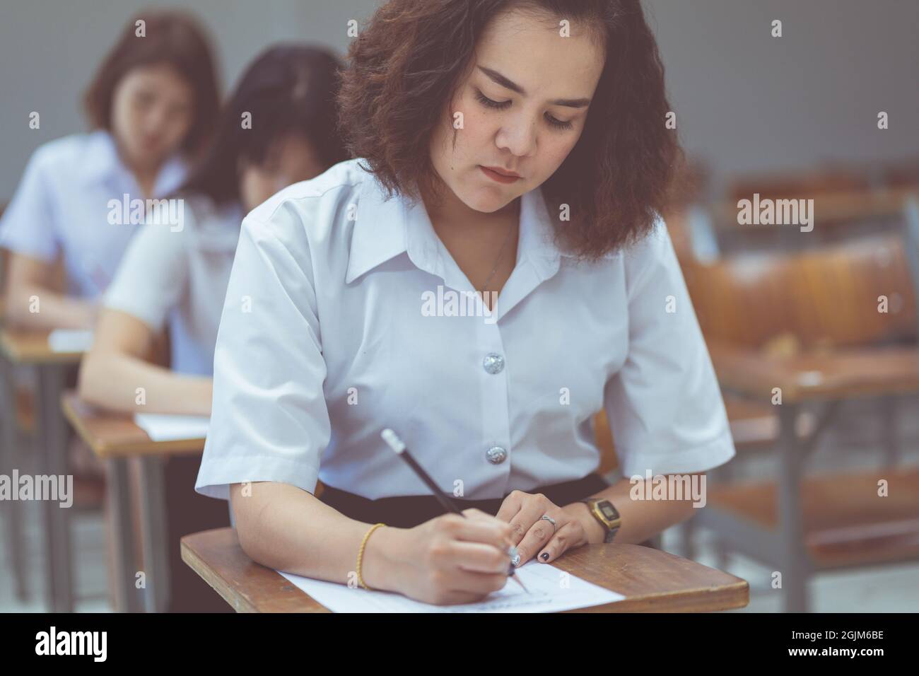 Group of Asian female college students taking notes while studying in a ...