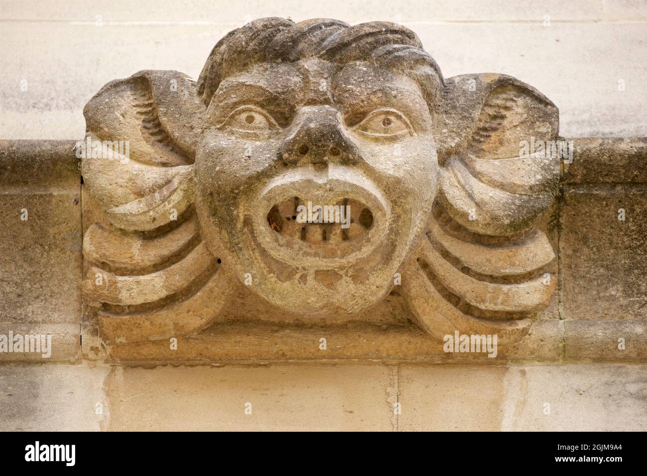 Stone carved gargoyle of a face on the exterior of Magdalen College ...