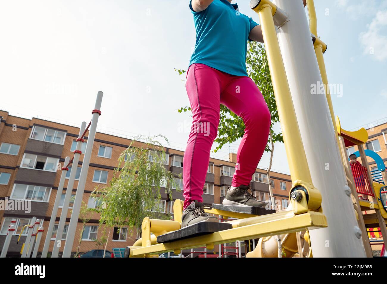 young woman working out on the street gym machine elliptical cross ...