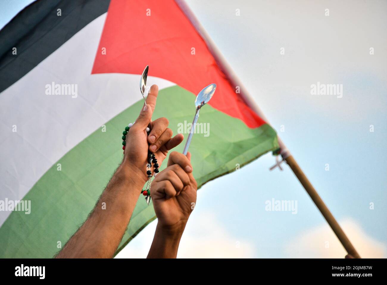 Arab Israeli protestors waving Palestine flags and spoons, which were ...