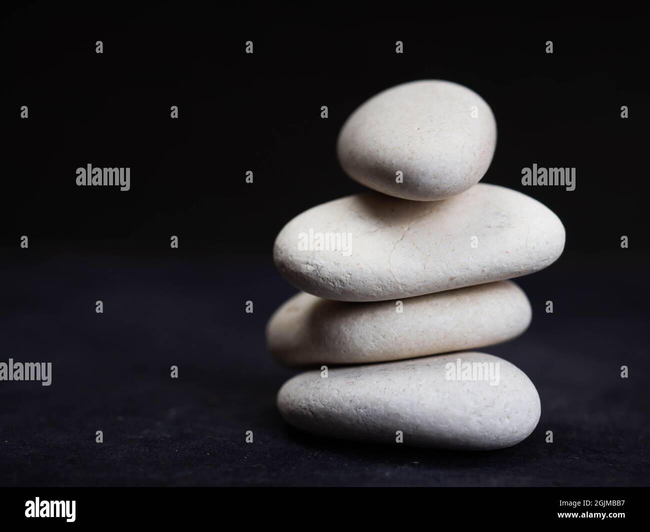 Picture of stacked white stone on a black background Stock Photo - Alamy