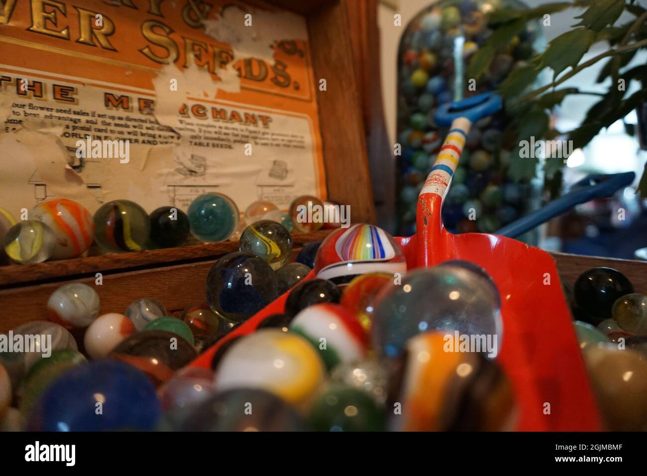 Colorful box of marbles being scooped by a red shovel with a blue ...