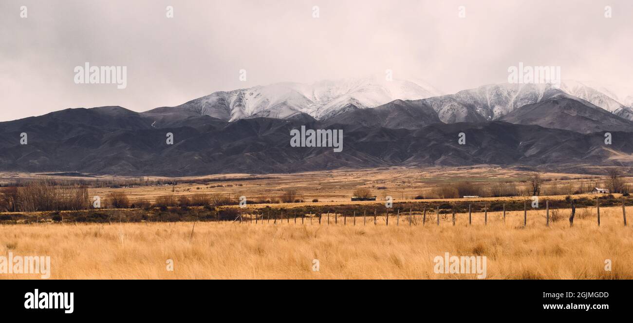 Snowy Andes Mountains looming over vast dry grasslands in Tupungato ...