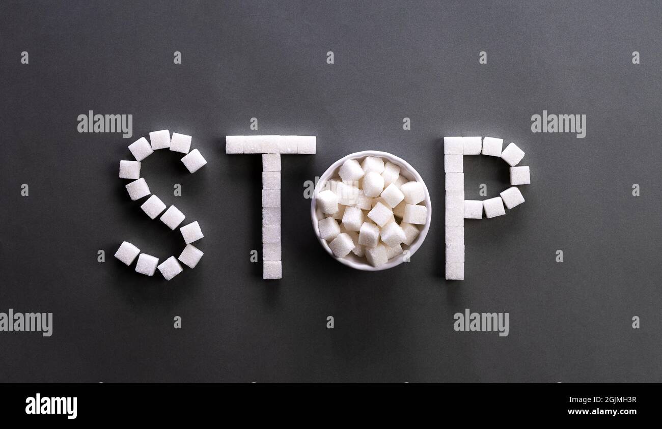 Top view of sugar made STOP sign on dark gray background, warning that ...