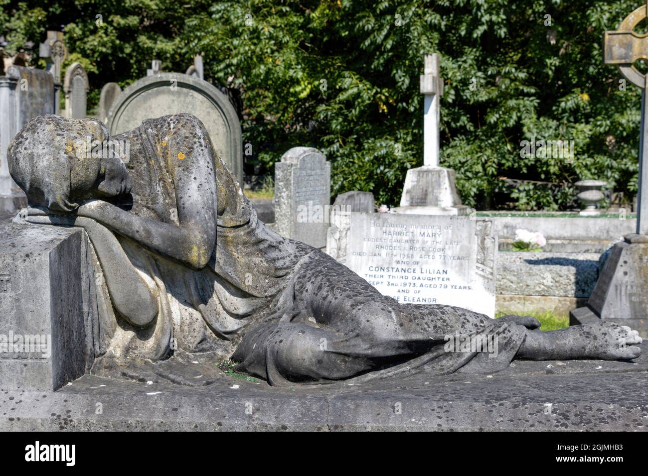 A stone Statue of a lady laying on top of a tomb at Locksbrook Cemetery ...