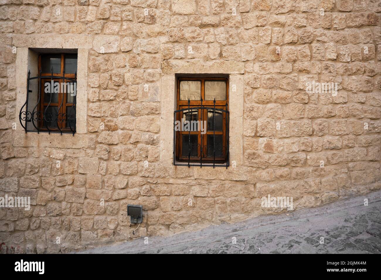 Angled way made of and covered by cobblestone and wooden window on ...