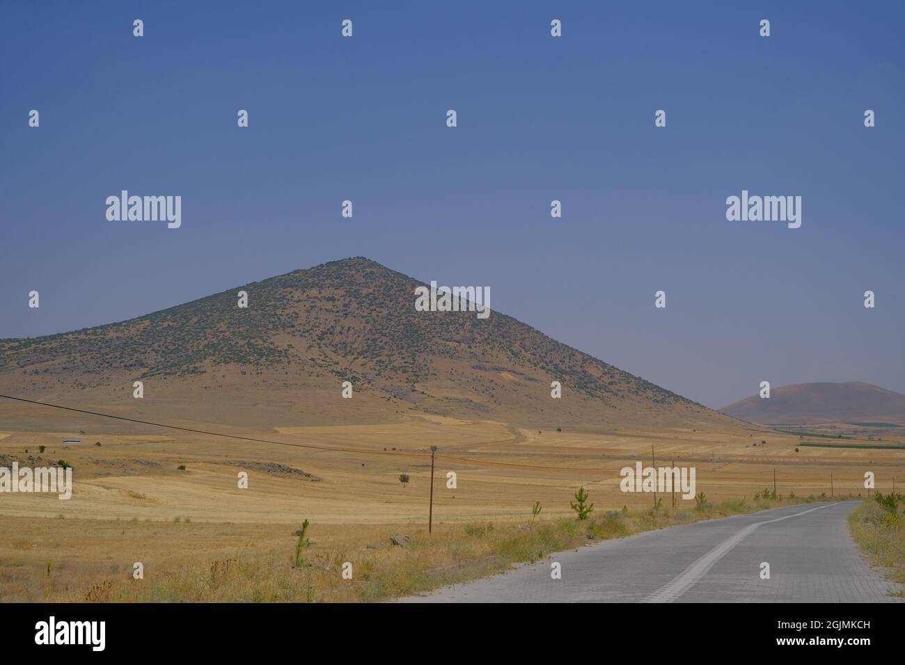 Small single hill and asphalt road with white road lines in Nevsehir ...