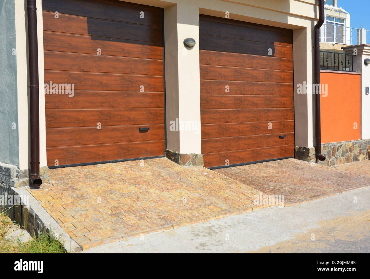 Garage door for two cars with pathway pavement and plastic gutter pipes ...