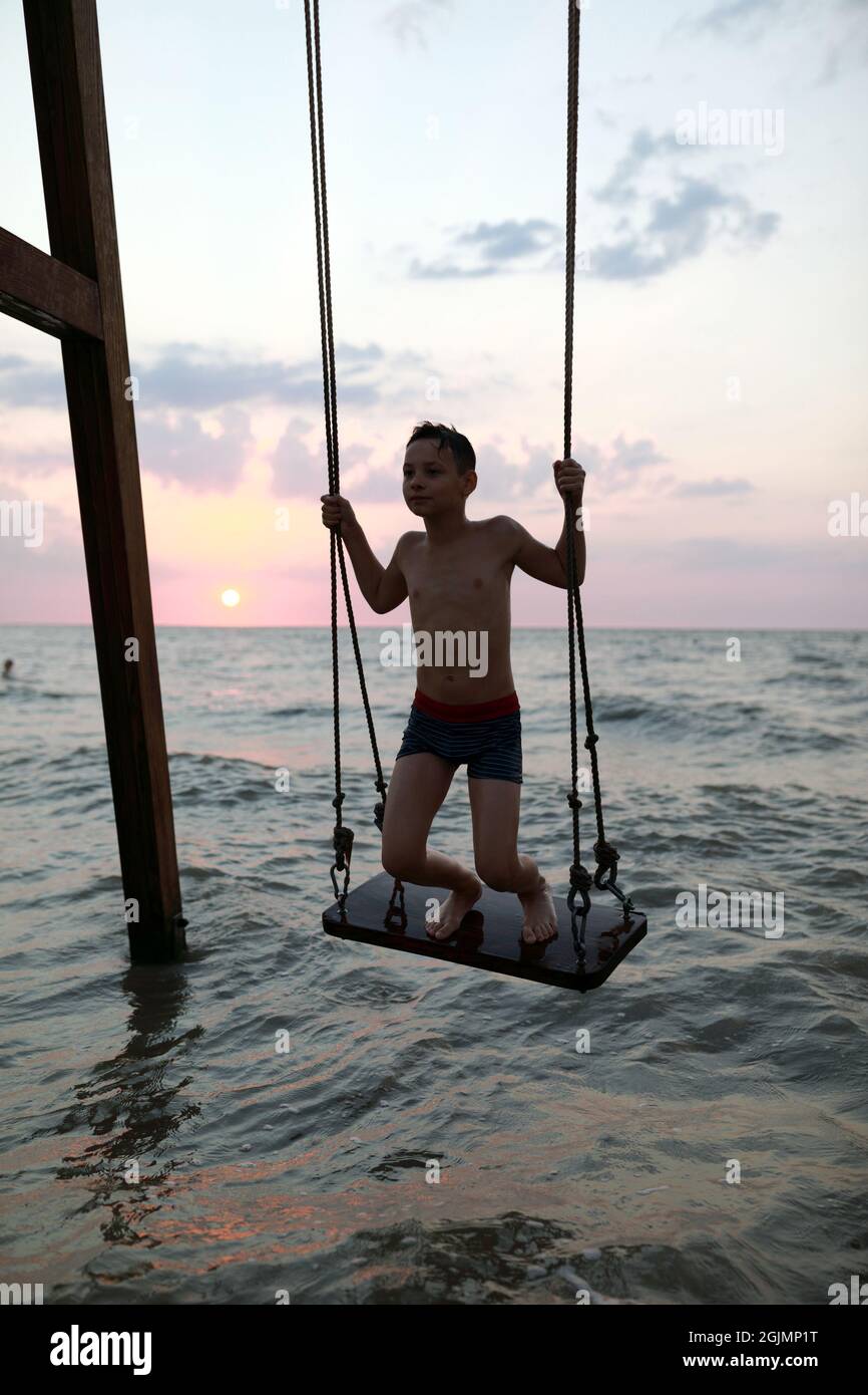 Beautiful boy swinging on swing hi-res stock photography and images - Alamy