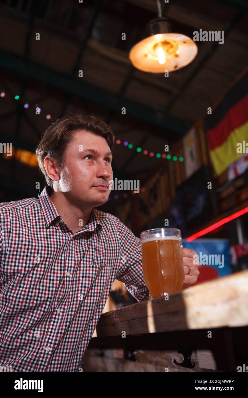 Vertical portrait of a man drinking beer at bar counter Stock Photo - Alamy