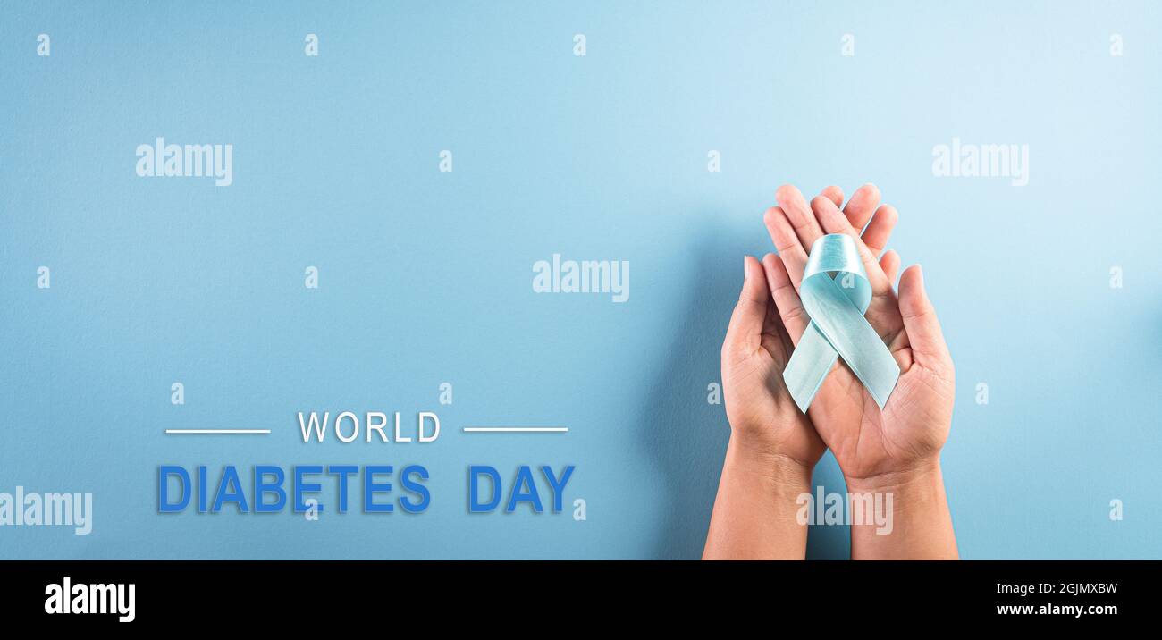 World diabetes day concept. Hand holding blue ribbon, symbolic bow ...