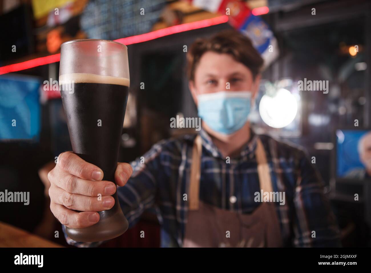 Close up of a professional brewer wearing medical face mask, holding ...