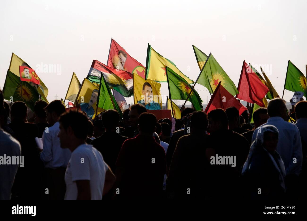 Kurdish men hold flags bearing the image of Abdullah Ocalan founding ...