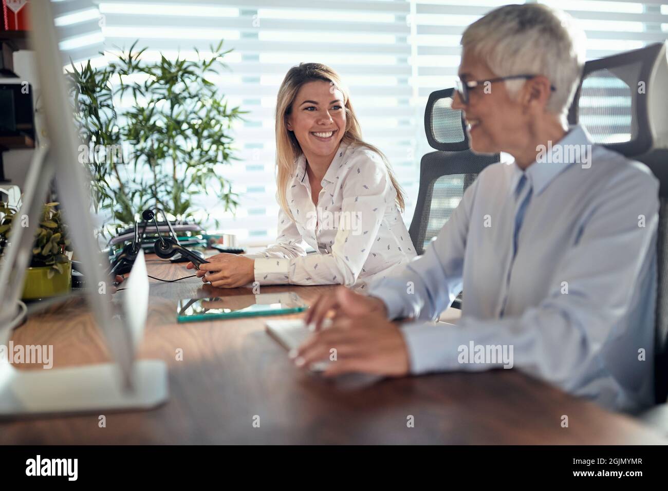 Female colleagues are enjoying working together at the office on a ...