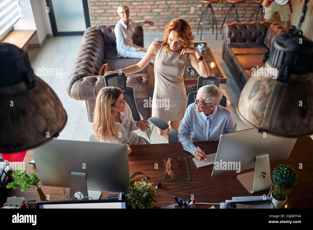 Group of female colleagues are having a friendly talk while having a ...