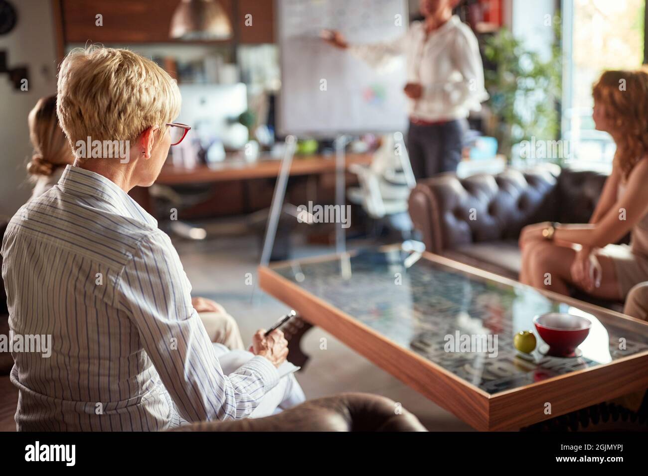 Group of female office staff is carefully listening to a female ...