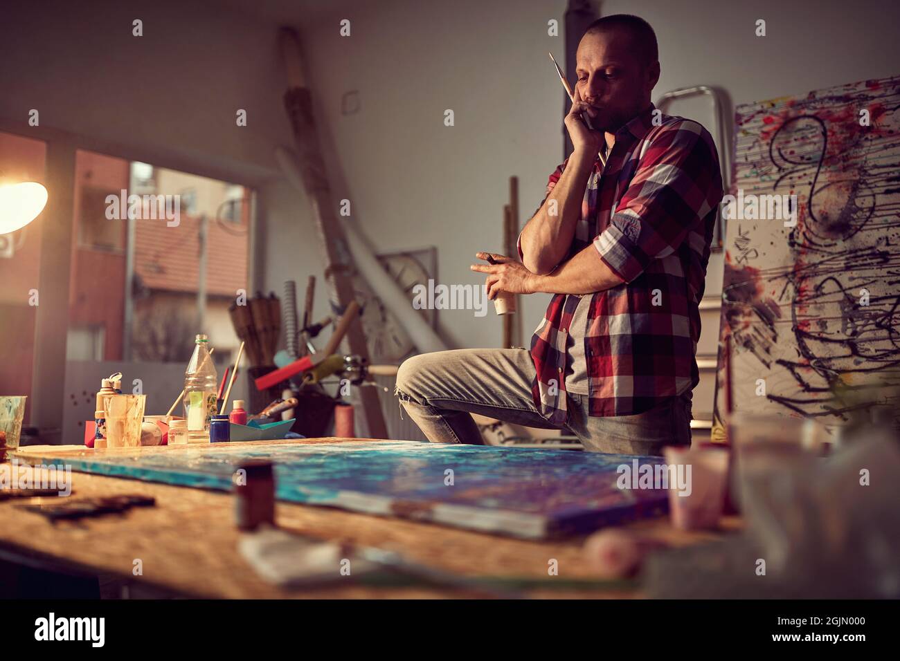 A young male artist in a creative process while working on his new ...